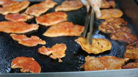 Chunks of meat are cooked in a wide pan ... | Stock Video | Pond5