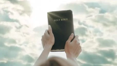 Cinemagraph of lifting Bible up to sky i... | Stock Video | Pond5