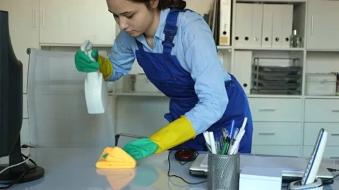 Cleaning lady in overalls wipes dust fro... | Stock Video | Pond5