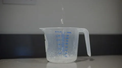 Clear liquid pouring into measuring jug ... | Stock Video | Pond5