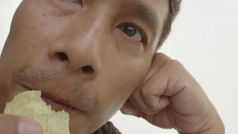 Close-up Asian man eating potato chips, ... | Stock Video | Pond5