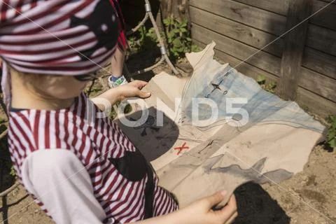 Close-up of a boy examining a treasure map in a adventure playground ...