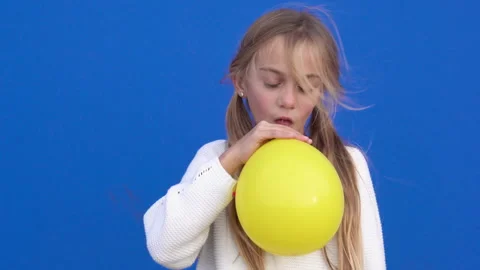 Close up of a cheerful girl inflating a ... | Stock Video | Pond5