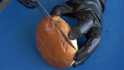 Close-up of chef's hand cutting burger b... | Stock Video | Pond5