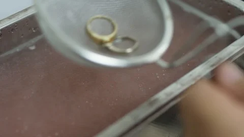 Close-up of dipping gold rings into the ... | Stock Video | Pond5