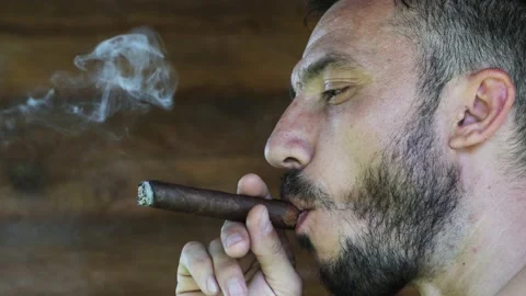Close-up face of a man smoking a cigar. ... | Stock Video | Pond5