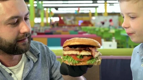 Close-up of father and son eating burger... | Stock Video | Pond5