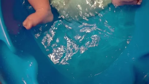 Close-up feet of a newborn baby splash i... | Stock Video | Pond5