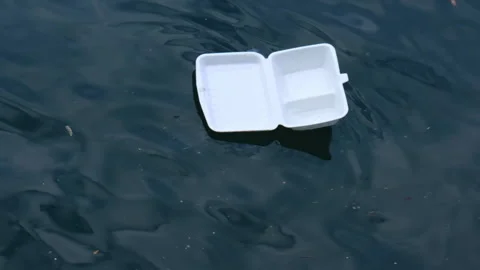 Close up a foam food container floating ... | Stock Video | Pond5
