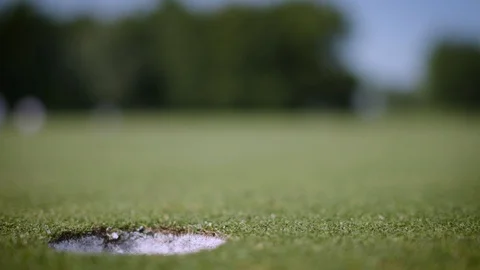 Close up golf ball falling in hole on pu... | Stock Video | Pond5