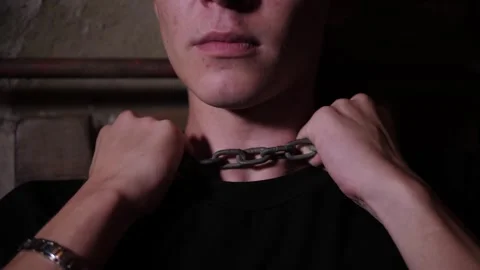 Close-up of a guy chained by the neck in... | Stock Video | Pond5
