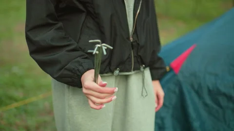 Close Up of Lady Twirling Tent Peg Durin... | Stock Video | Pond5