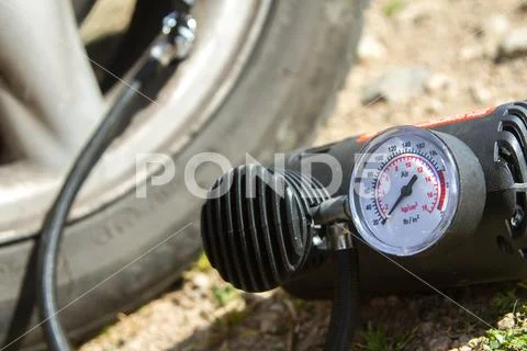 Close up of a mini compressor with pressure gauge which inflates the ...