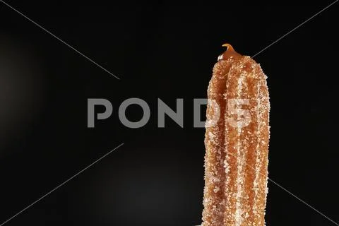 Photograph: Close up shot of a churro filled with dulce de leche on ...