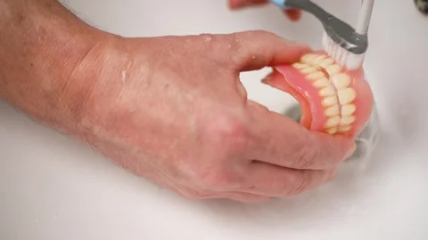 Close-up shot of cleaning dentures with ... | Stock Video | Pond5