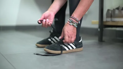 Close up on a woman lacing her shoes on ... | Stock Video | Pond5