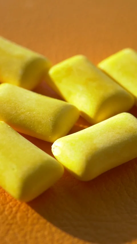 Close-up of yellow chewing gum pieces on... | Stock Video | Pond5