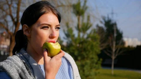 Close-up young cute woman eats green app... | Stock Video | Pond5