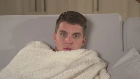 CLOSE UP: Young guy gets scared watching... | Stock Video | Pond5