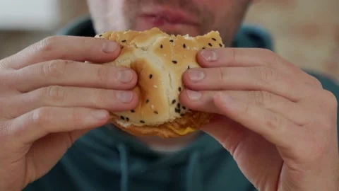 Close-up of a young man greedily eating ... | Stock Video | Pond5