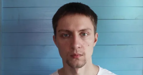 closeup guy on a blue background puts on... | Stock Video | Pond5