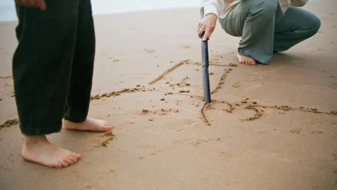 Closeup hand draw beach sand on family w... | Stock Video | Pond5