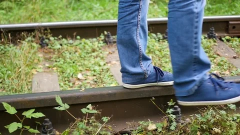 Closeup. The legs are on train tracks. T... | Stock Video | Pond5