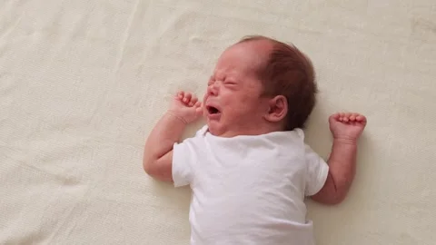 Closeup of newborn baby crying while lyi... | Stock Video | Pond5