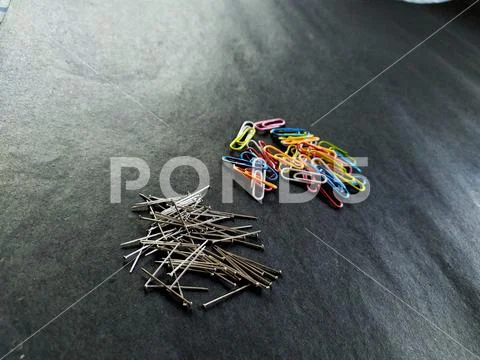 Closeup of paper clip and pin, black background Stock Image #125461011