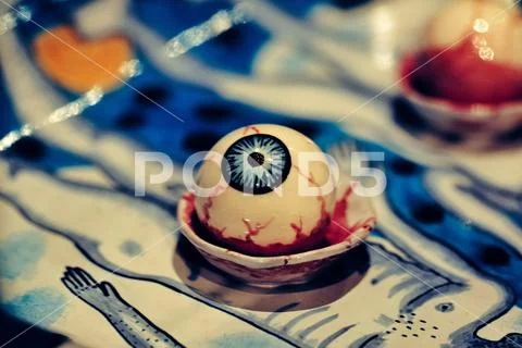 Closeup of a plastic anatomic model of an eyeball on an anatomy poster ...