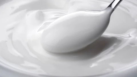 Closeup shot of mixing yogurt with spoon... | Stock Video | Pond5