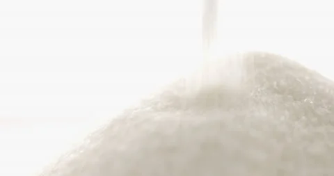 Closeup sugar falling, isolated on white... | Stock Video | Pond5