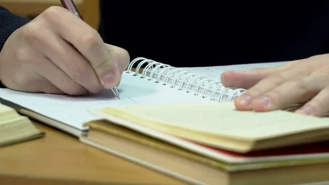 Closeup of young student making notes on... | Stock Video | Pond5