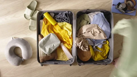 Clothes fall from above into open suitca... | Stock Video | Pond5