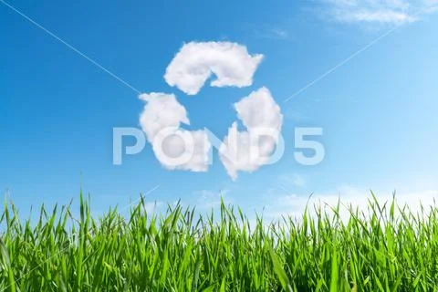Clouds on the blue sky in shape of the symbol of recycling on green ...