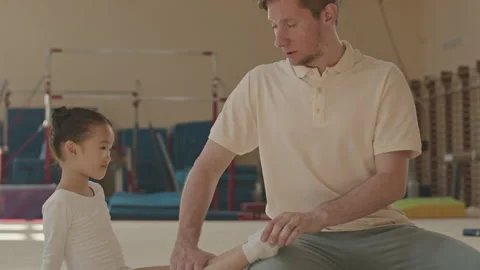Coach Stretching Little Asian Girl durin... | Stock Video | Pond5