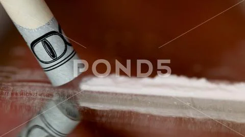 Photograph: Cocaine junkie snorting line of coke with rolled US dollar ...