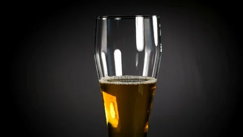 Cold light beer in a glass over black ba... | Stock Video | Pond5