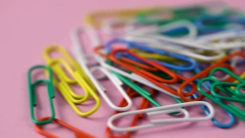 colored paper clips fall on the pink tab... | Stock Video | Pond5