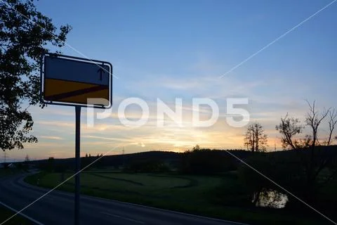 Colorful road sign on the evening highway in perspective on the ...