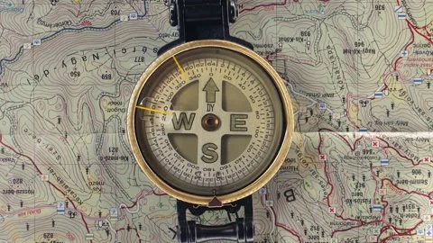 Compass spinning over a hiking map | Stock Video | Pond5