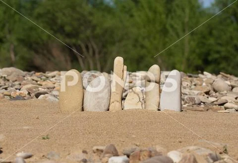 Photograph: A composition of stones, pebbles on a sandy-stone beach ...