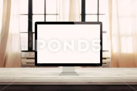 Computer display on desk et home office interior with windows in the ...