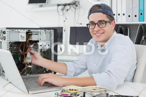 Computer engineer working on broken console with laptop Stock Image #40940061