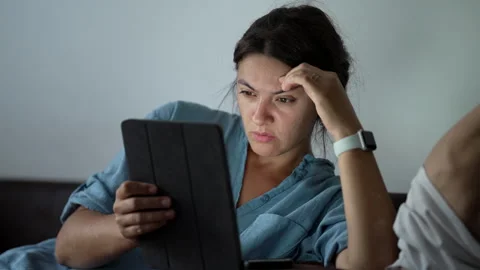 Concentrated candid woman staring at dev... | Stock Video | Pond5