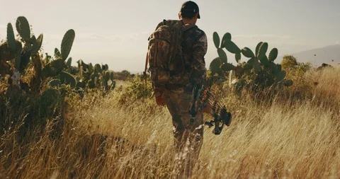 Confident bow hunter calmly walks and ob... | Stock Video | Pond5