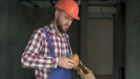 Construction worker in helmet eating bur... | Stock Video | Pond5