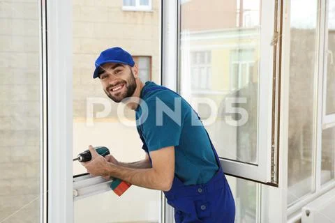 Construction worker using drill while installing window indoors Stock ...