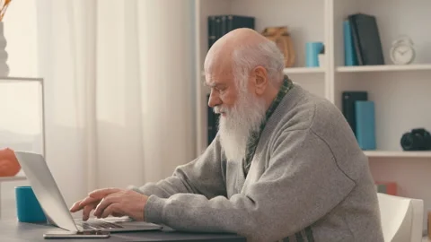 Contemporary grandpa typing on laptop at... | Stock Video | Pond5