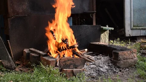 Controlled log fire outside surrounded b... | Stock Video | Pond5